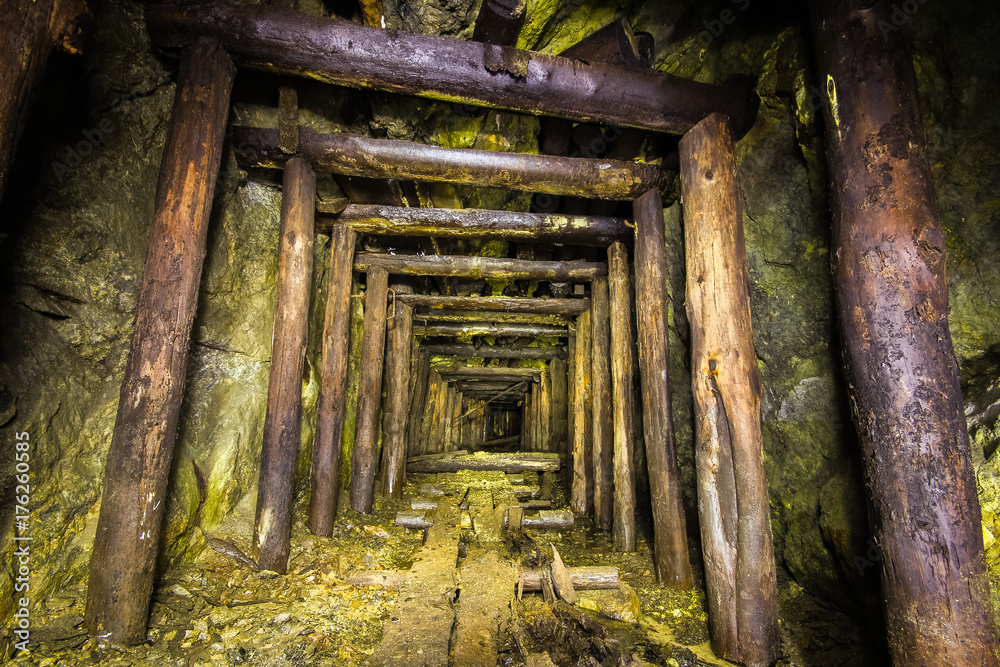 Underground abandoned ore mine shaft tunnel gallery passage with wooden ...