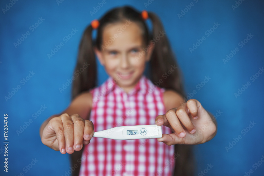 Happy little girl looking at the thermometer, her temperature was 36.6 ...
