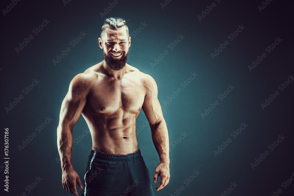 Smiling guy bodybuilder posing. Beautiful sporty guy male power ...