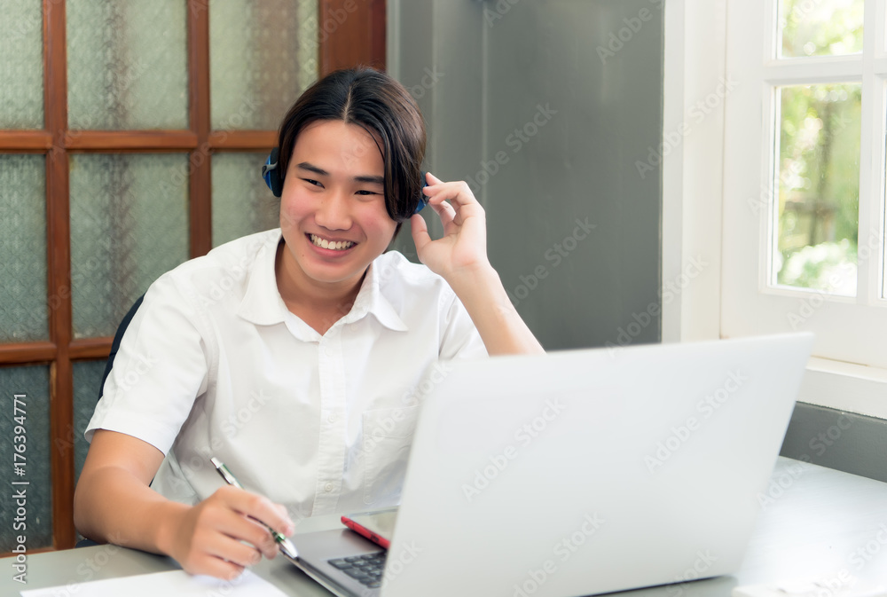 Student studying and writing notes in a notebook sitting at a desk at ...