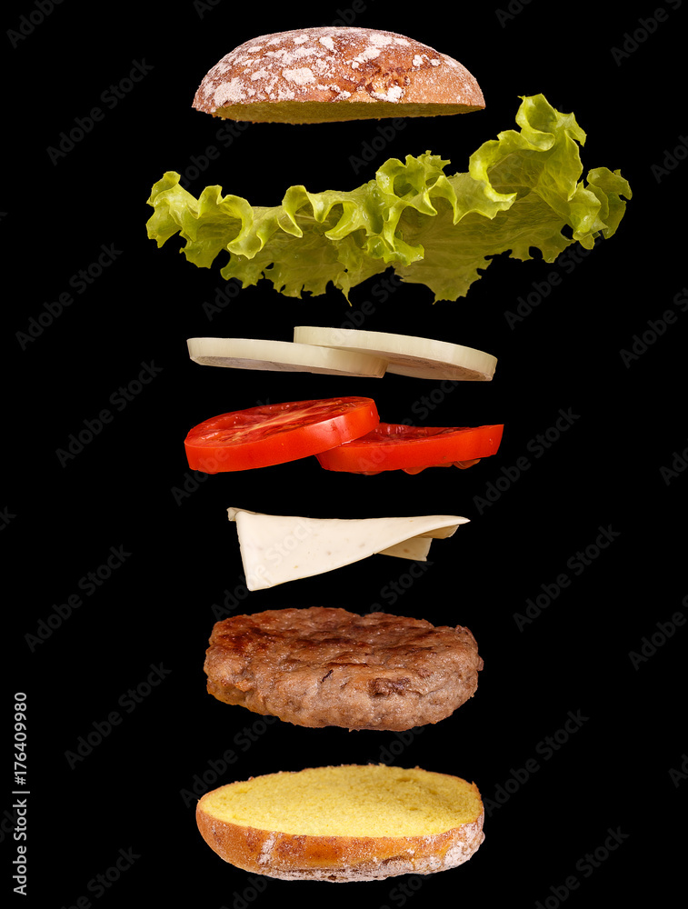 Burger parts flying in air isolated on black Stock Photo | Adobe Stock