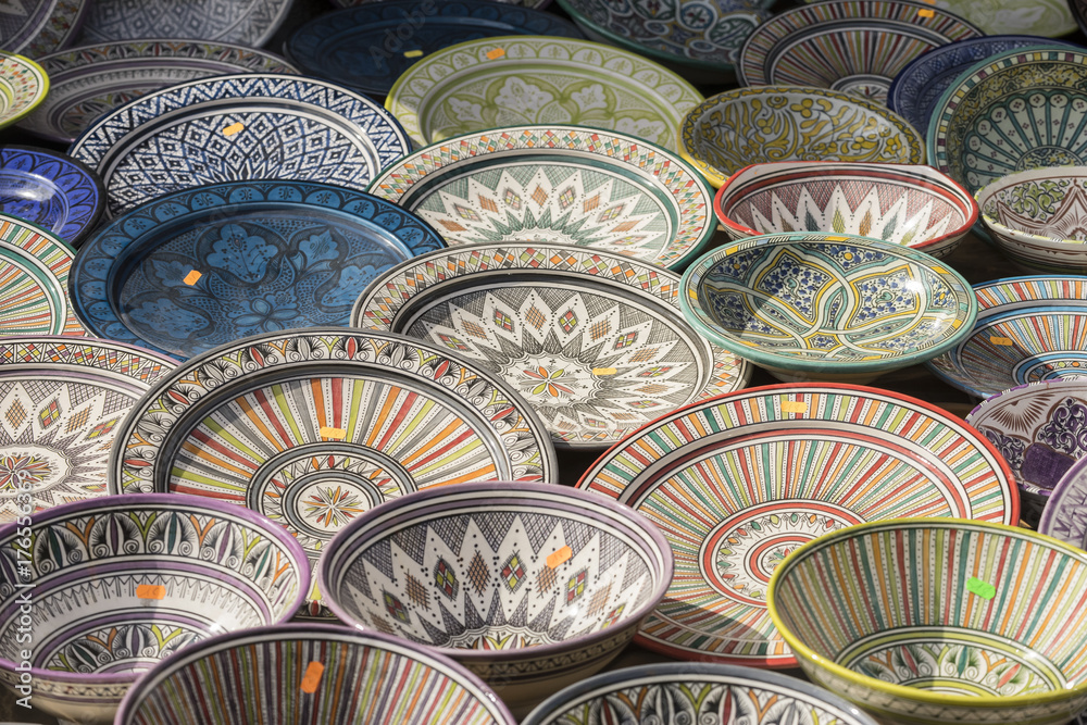 Decorative, hand-painted dishes of a multitude of colors in a ...