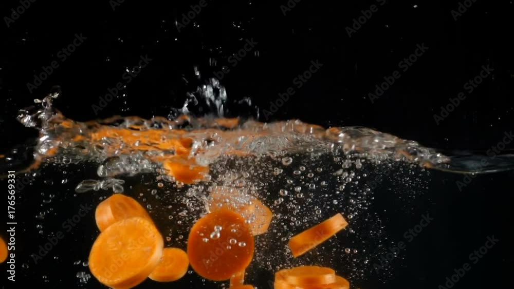 sliced carrots falling in water on black background Stock Video | Adobe ...