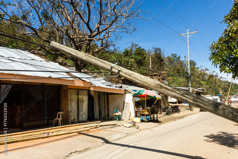 Damaged powerlines and poles following the passage of a major hurricane ...