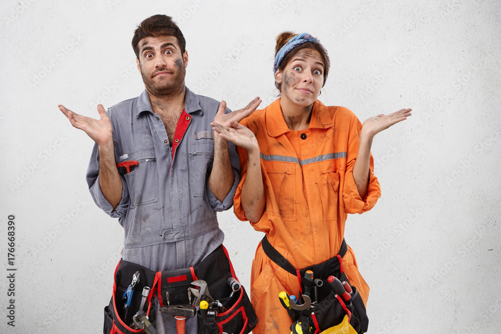 Puzzled female and male plumbers can`t understand where breakage is ...