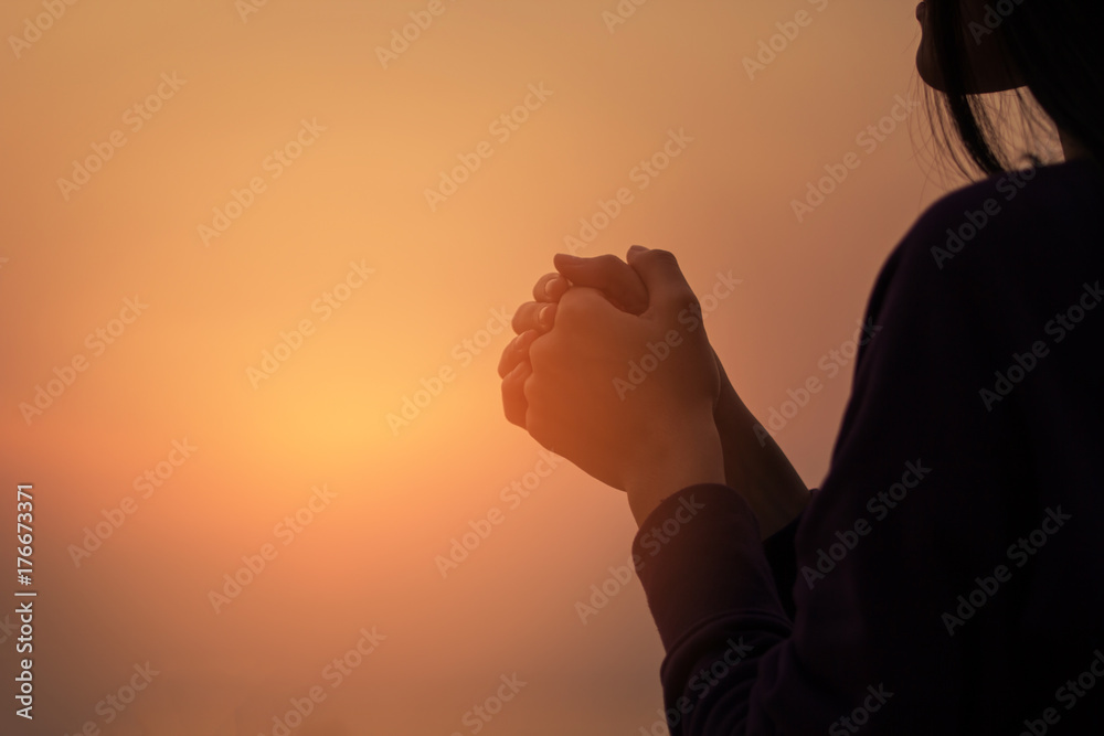 Christian woman praying worship at sunset. Hands folded in prayer ...