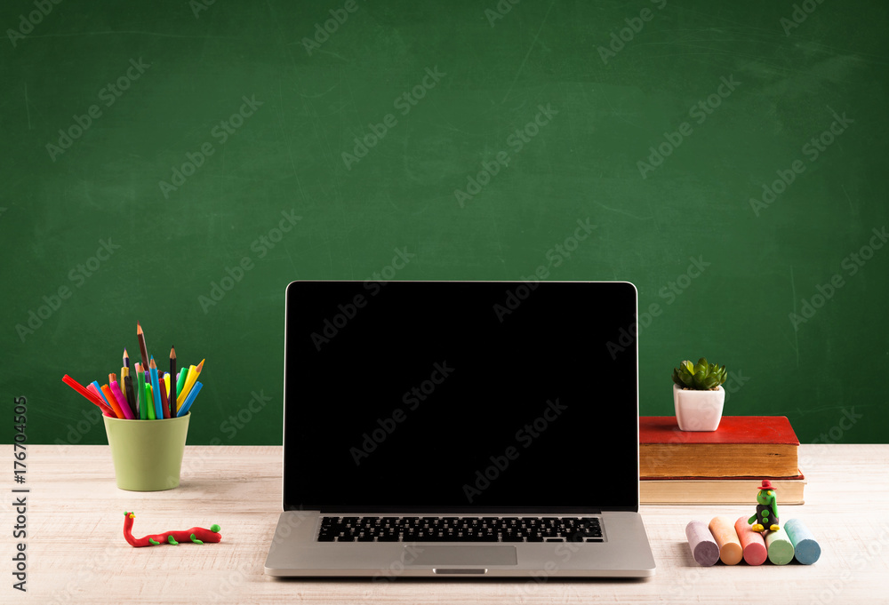 School items on desk with empty chalkboard Stock Photo | Adobe Stock