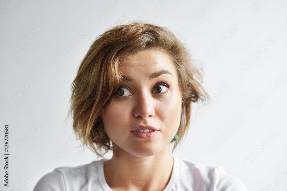 Headshot of emotional young woman with short hairstyle looking away ...