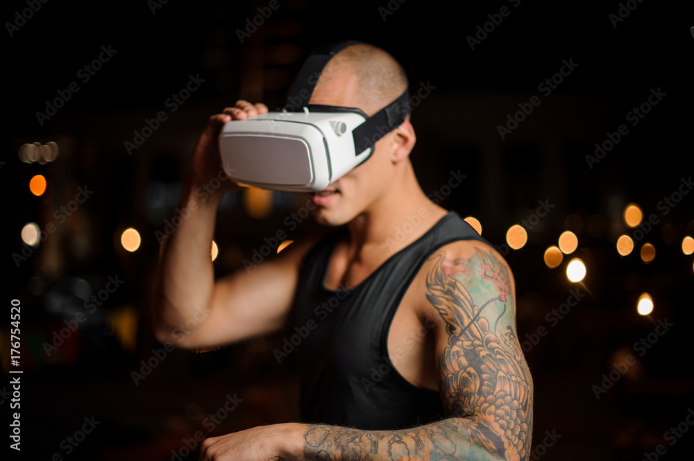 Foto Stock Muscular and tattooed handsome man in night vision glasses ...