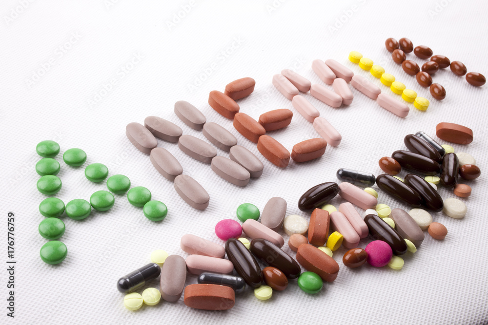 Hand writing Medical care concept written with pills drugs capsule word ...