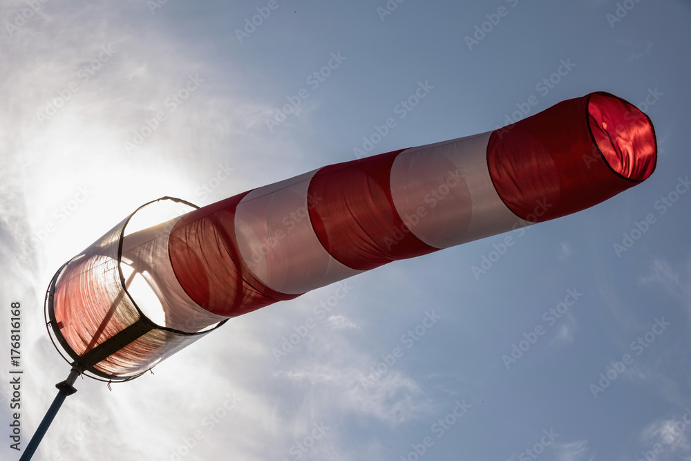 Airport windsock on clear blue sky background in windy weather indicate ...