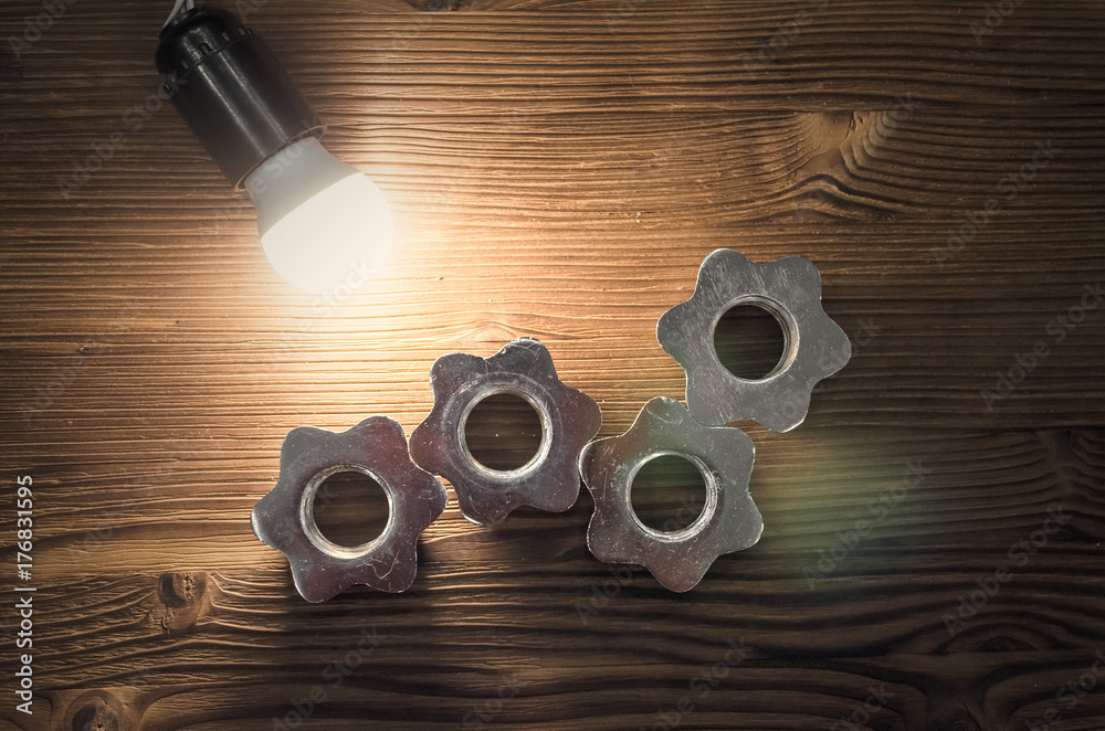 Transmission mechanism made of gears in the light of burning bulb lamp ...