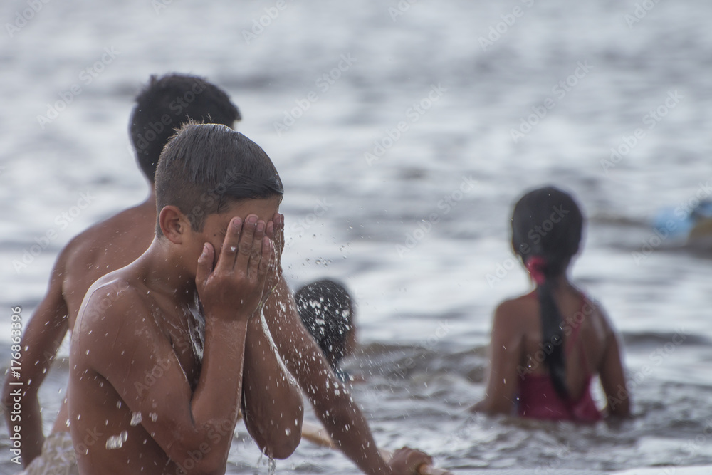 young man washing his face in the Ganges river enjoying a common day in ...