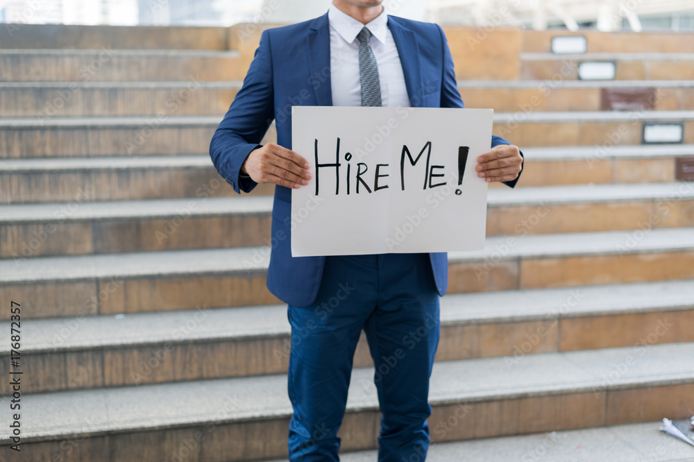 Hire me! Handsome businessman wear blue suit holding poster with hire ...