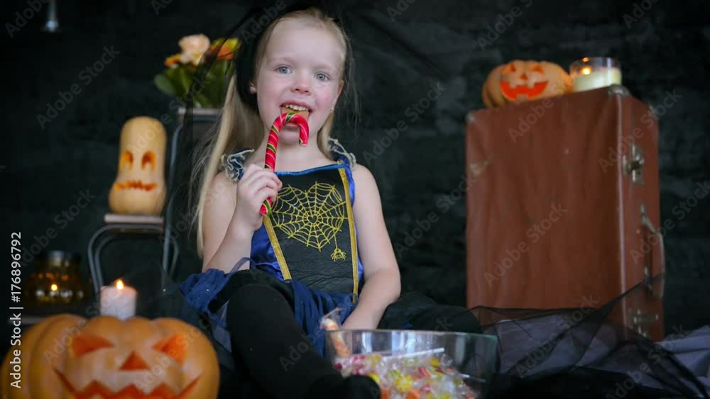 Vidéo Stock Little girl, little witch celebrate Halloween. Eat and ...