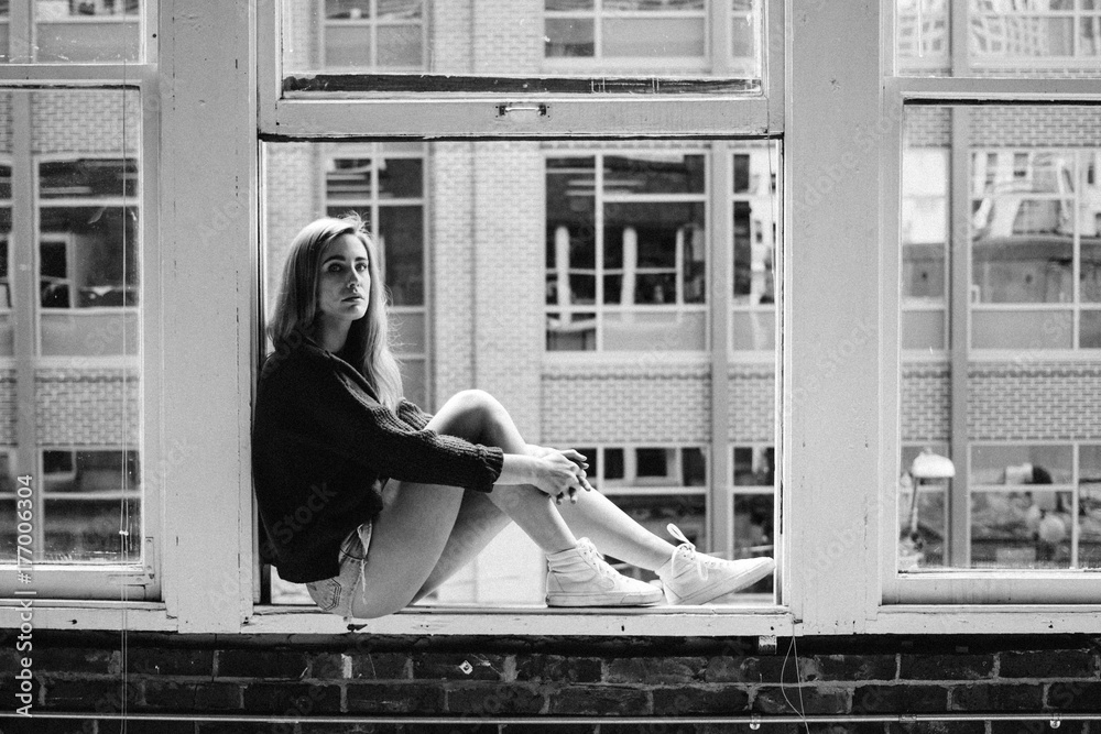 young attractive female in short denim shorts and sweater sitting in ...