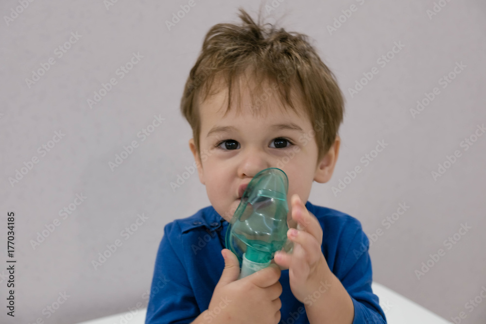 boy have a problem with chest coughing holding inhaler mask by him self ...
