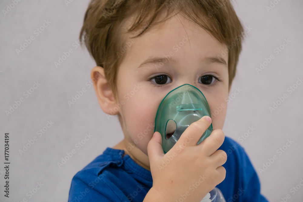 boy have a problem with chest coughing holding inhaler mask by him self ...