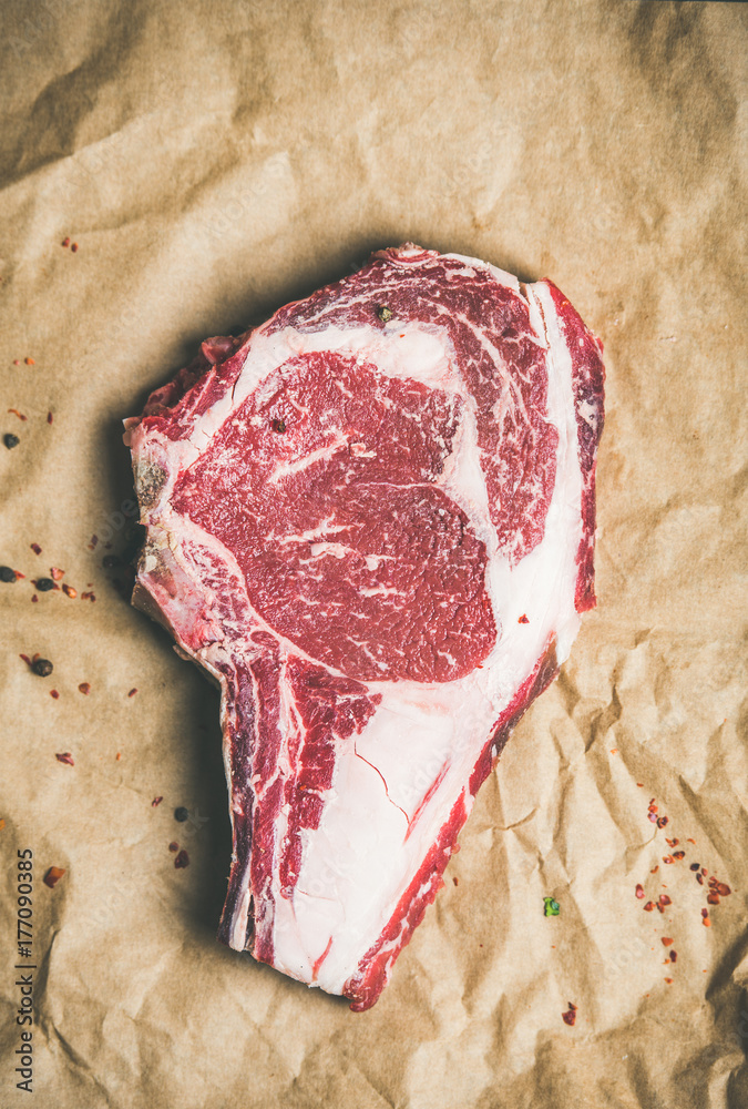Flat-lay of raw uncooked prime beef meat dry-aged steak rib-eye on bone ...