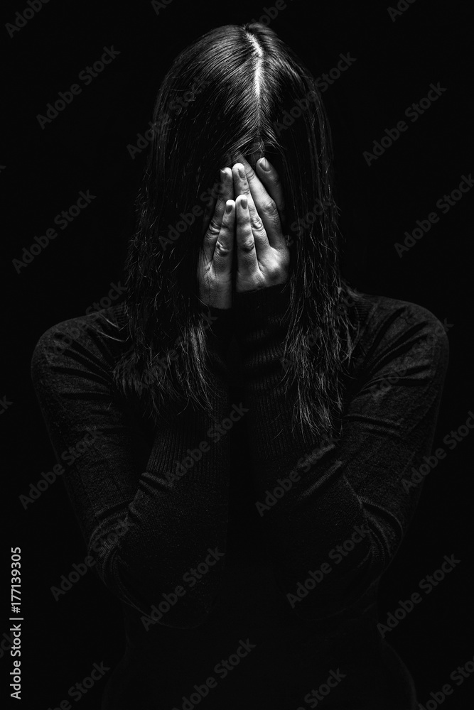 Emotional woman crying and covering the face with the hands hiding the ...
