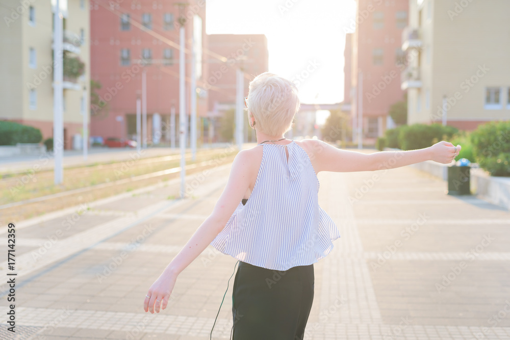 back view young woman outdoor back light walking spreading arms ...