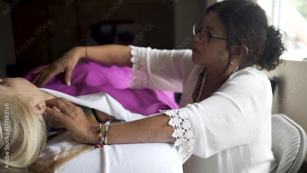 Polarity therapist has one hand on her client’s chest and the other on ...