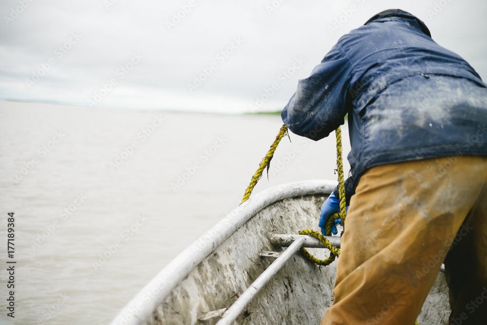 Fisherman throwing an anchor over a fishing boat Stock Photo | Adobe Stock