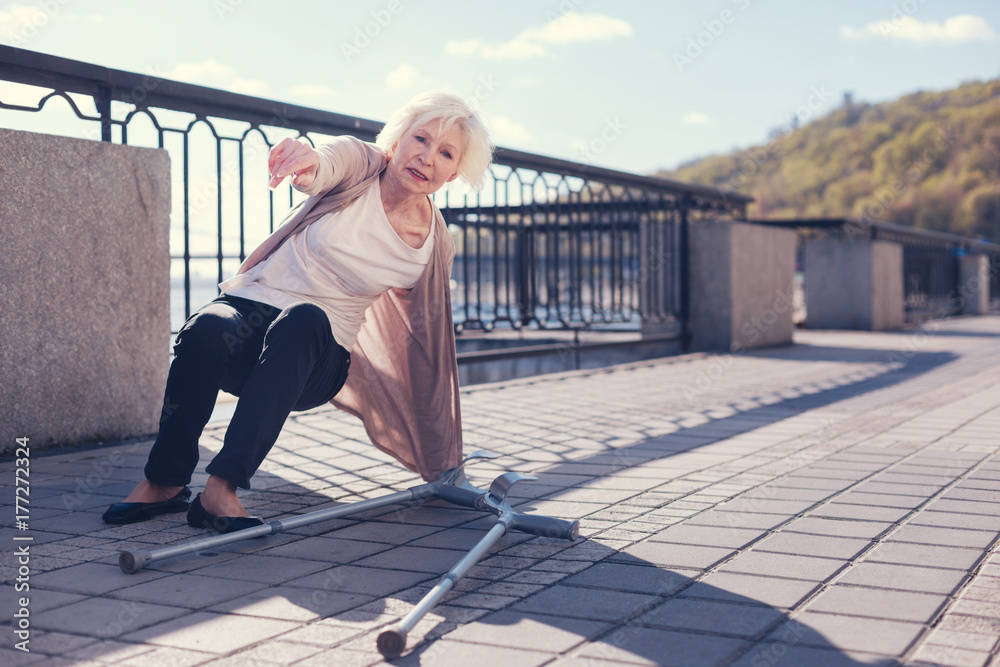 Elderly woman trying to get up after falling down Stock Photo | Adobe Stock