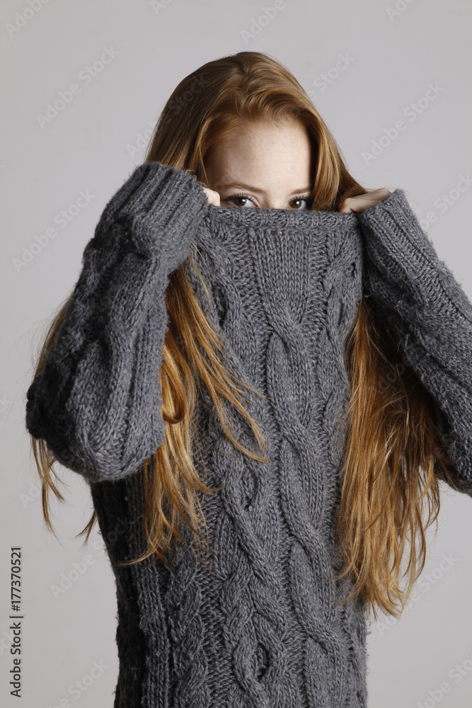 girl with long red hair pulling sweater over her face Stock Photo ...