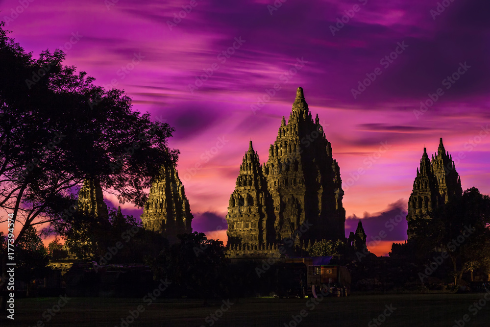 Candi Prambanan after sunset, illuminated from the side by the beams of ...