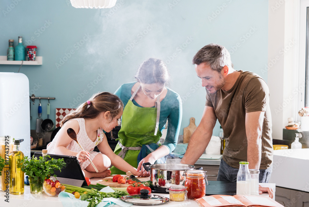 Dad, mom and their daughter cooking a recipe in the kitchen Stock Photo ...