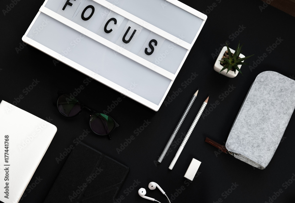 Black office table desk. Workspace with diary, plant, headphones ...