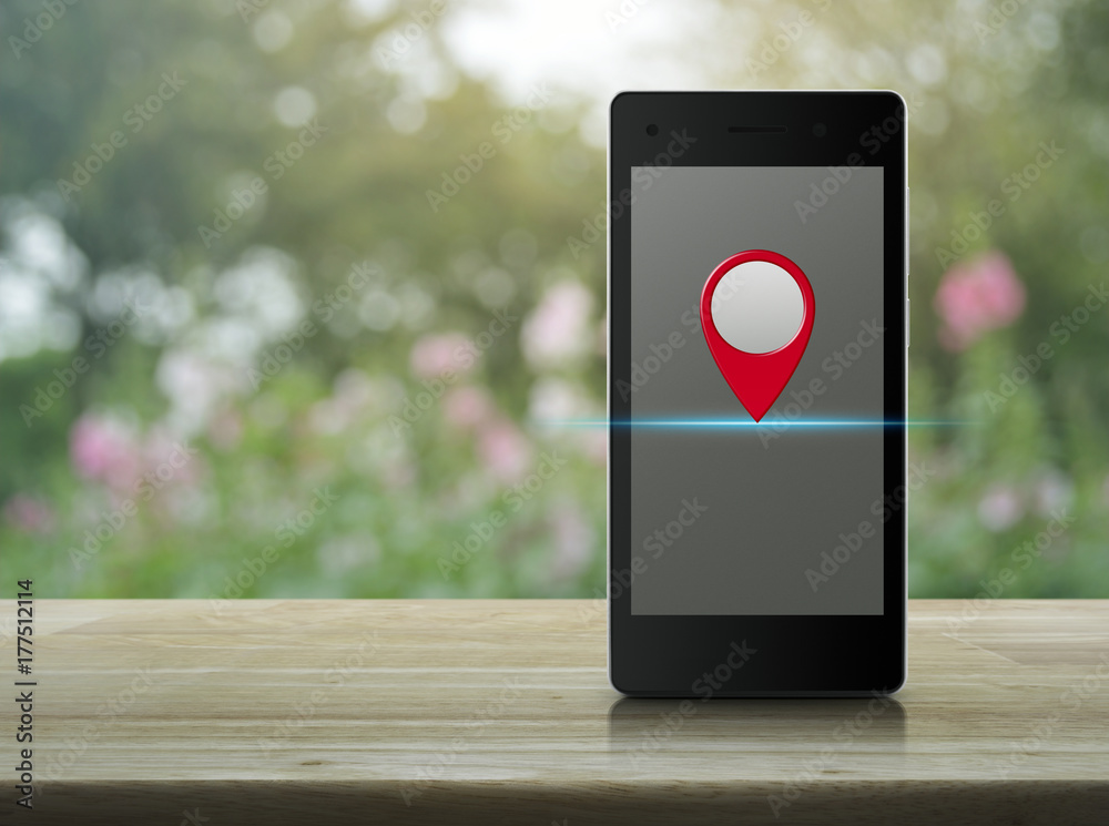 Map pin location button on modern smart phone screen on wooden table ...