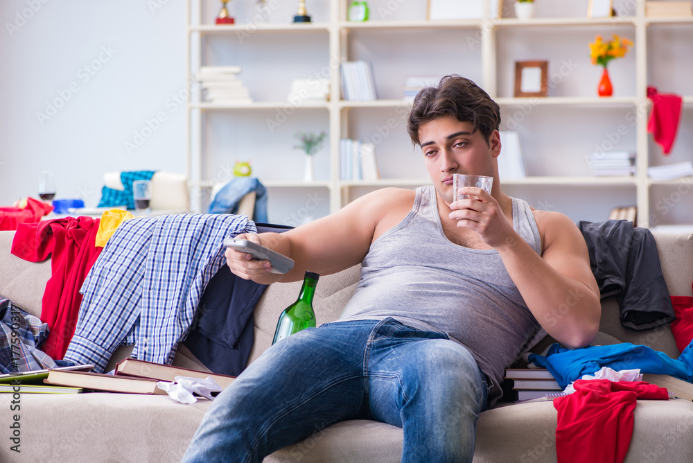 Young man student drunk drinking alcohol in a messy room Stock Photo ...