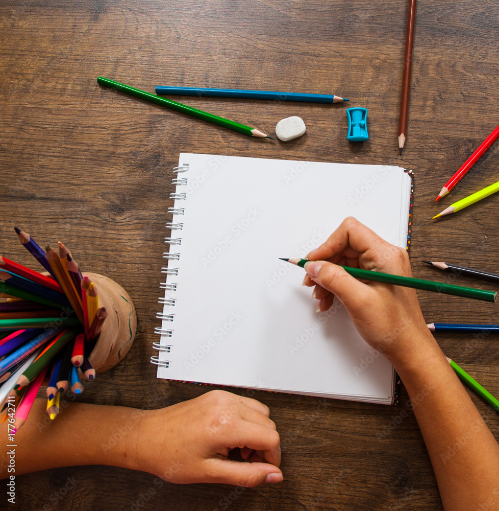 girl hand drawing, blank paper and colorful pencils on wooden table ...