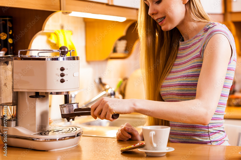 Woman in kitchen making coffee from machine Stock Photo | Adobe Stock
