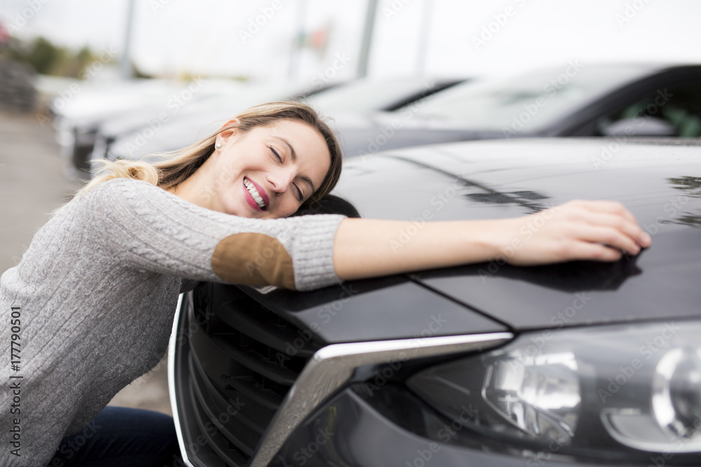 Jolly young female driver hugging her new car Stock Photo | Adobe Stock