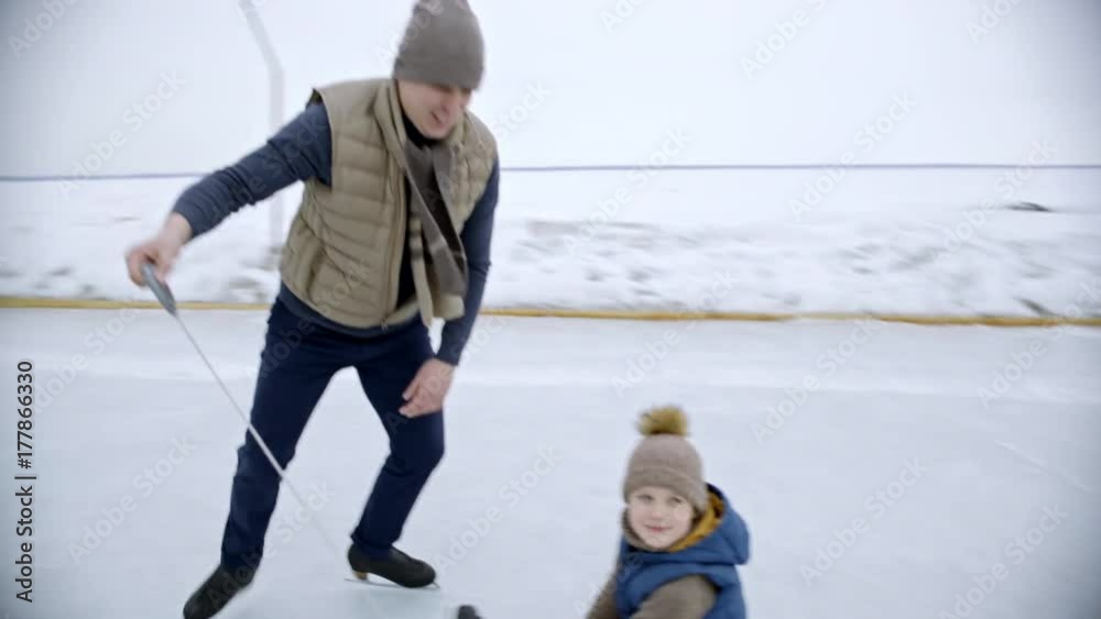 Handheld tracking of young man and woman skating on outdoor ice rink ...