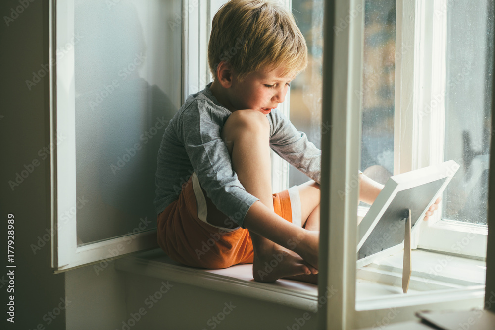 Sad rose cheeks barefoot smiling preschooler boy dressed home clothes ...