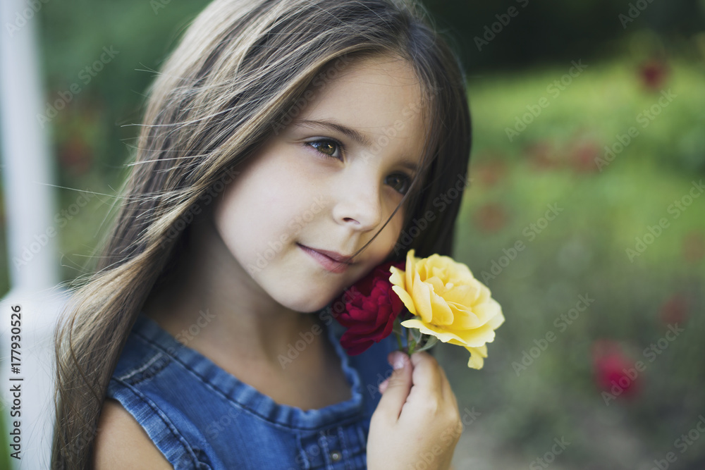 Little girl holding rose flower to her face Stock Photo | Adobe Stock