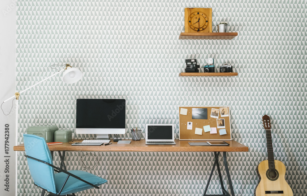 Office workspace with desk and computer against wallpaper Stock Photo ...