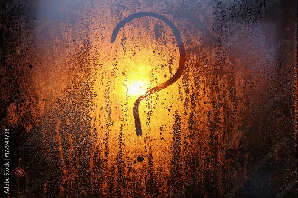 drawing in the form of a question mark on the sweaty glass of the ...