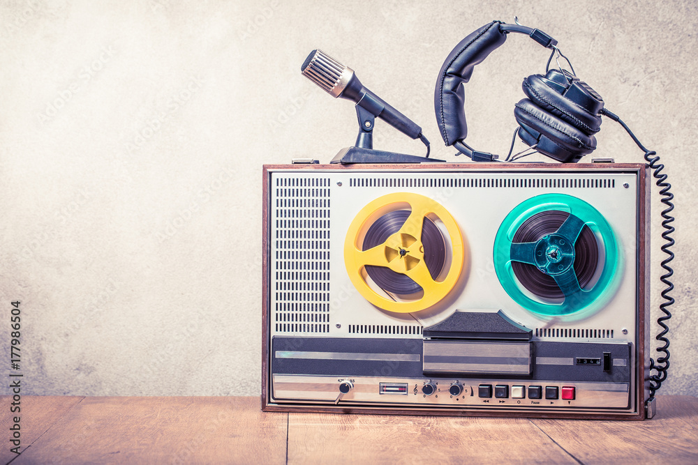Retro reel to reel tape recorder, microphone and headphones on wooden ...