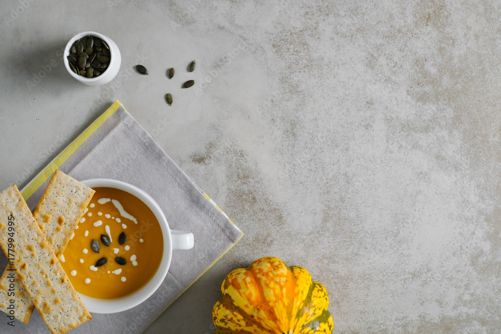Homemade pumpkin soup on minimal table top. Top view with copy space ...