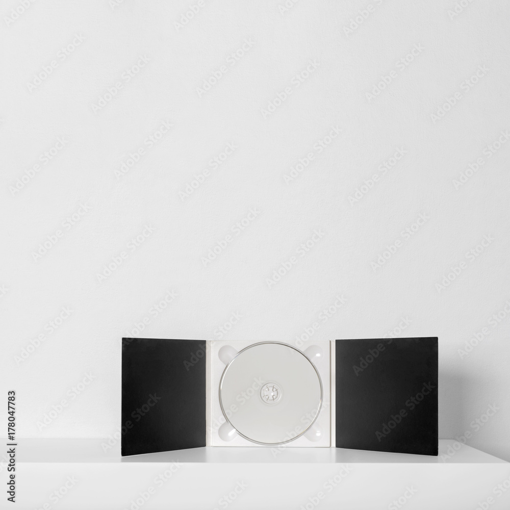Listen to the music, white cd in lack case on the shelf near the white ...