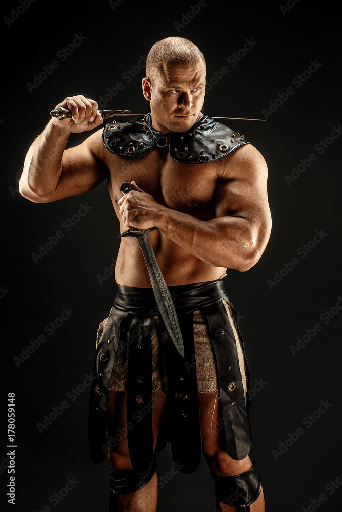 Severe barbarian in leather costume with two swords. Portrait of balded ...