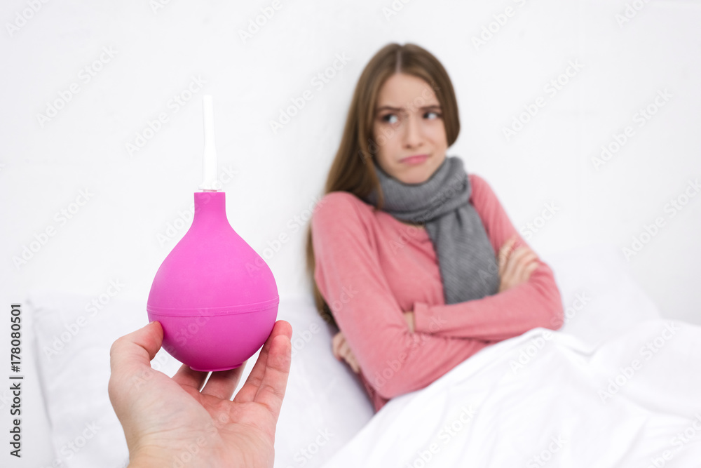 confused woman lookig at enema Stock Photo | Adobe Stock