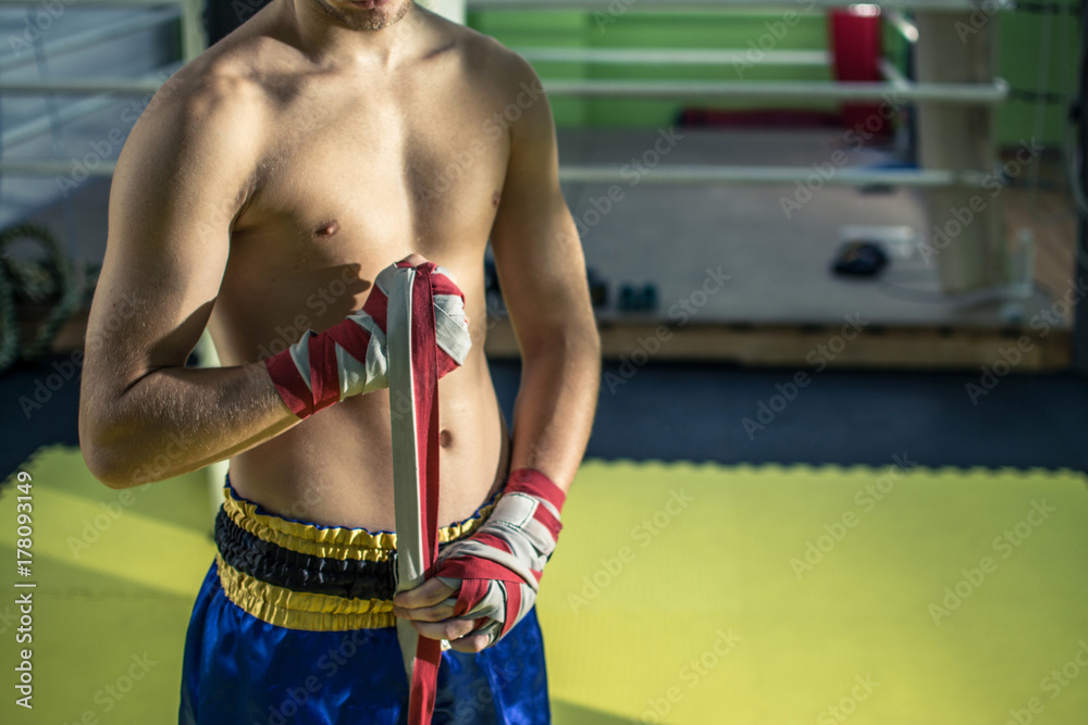 Boxer wrapping bandages on his hand before fight. Stock Photo | Adobe Stock