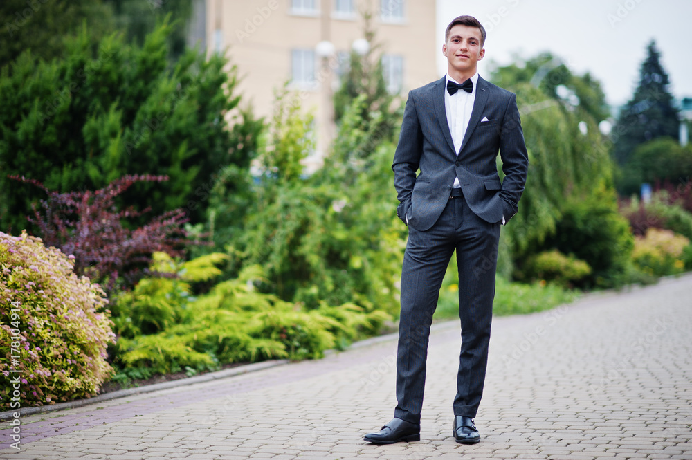 Portrait of a handsome young man in formal fancy suit posing on the ...
