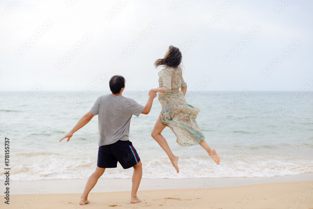 Adult young happy jumping couple on seashore outdoors nature sand ...